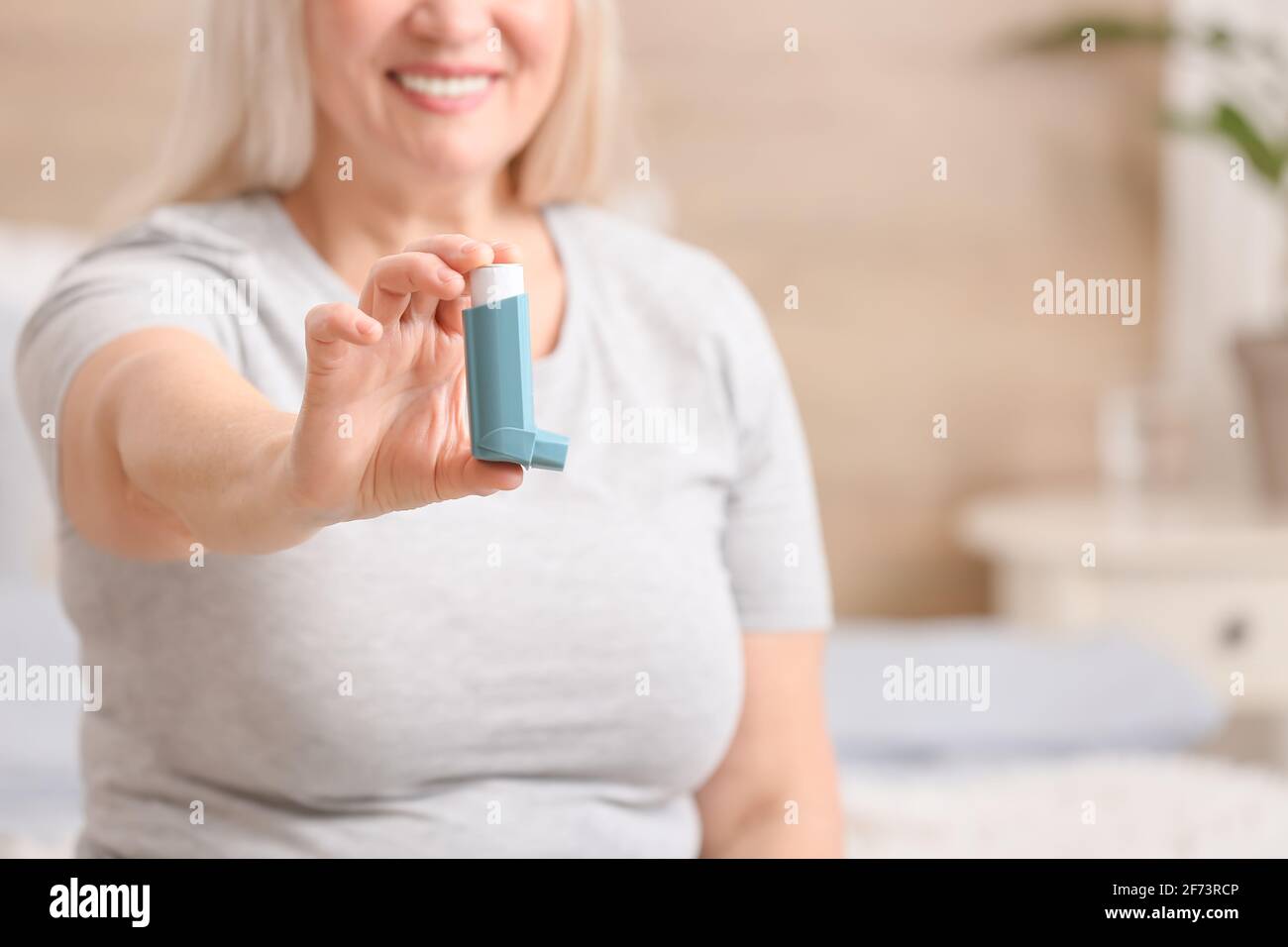 Mature woman with inhaler at home Stock Photo - Alamy