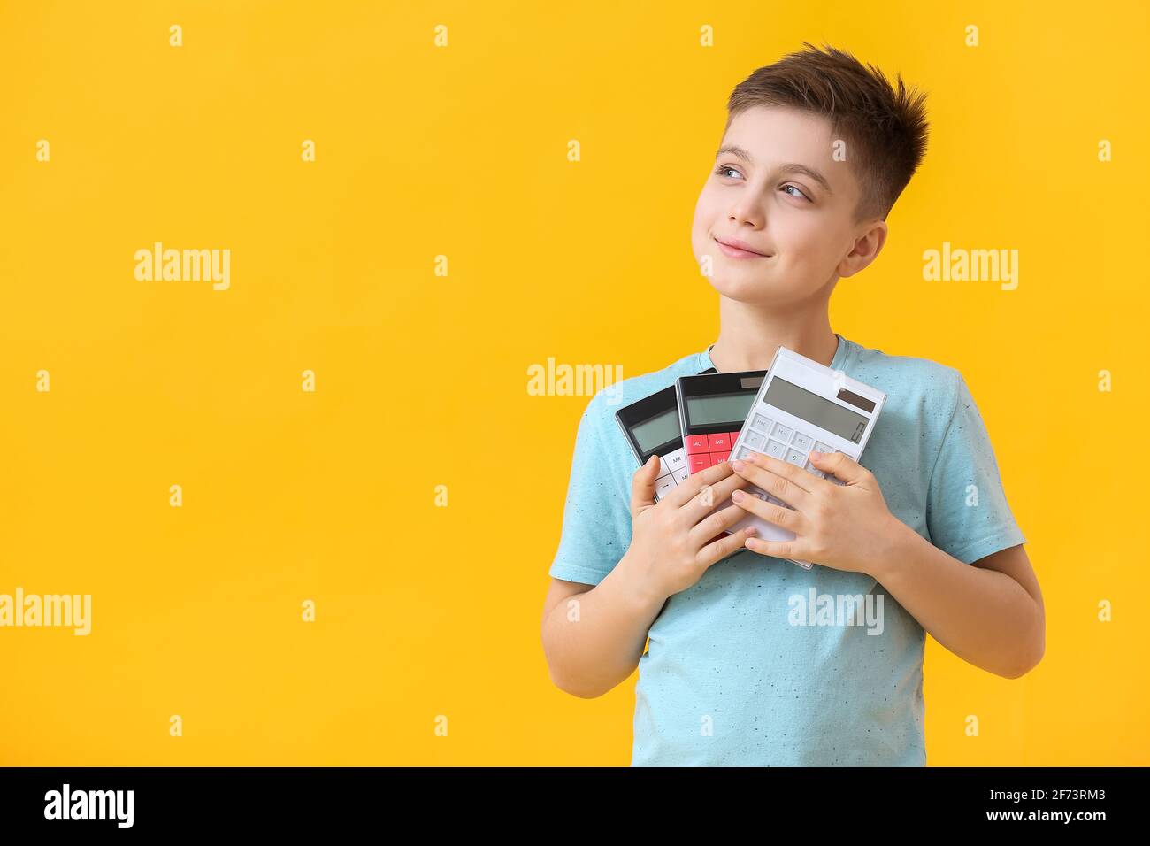 Little boy with calculators on color background Stock Photo - Alamy