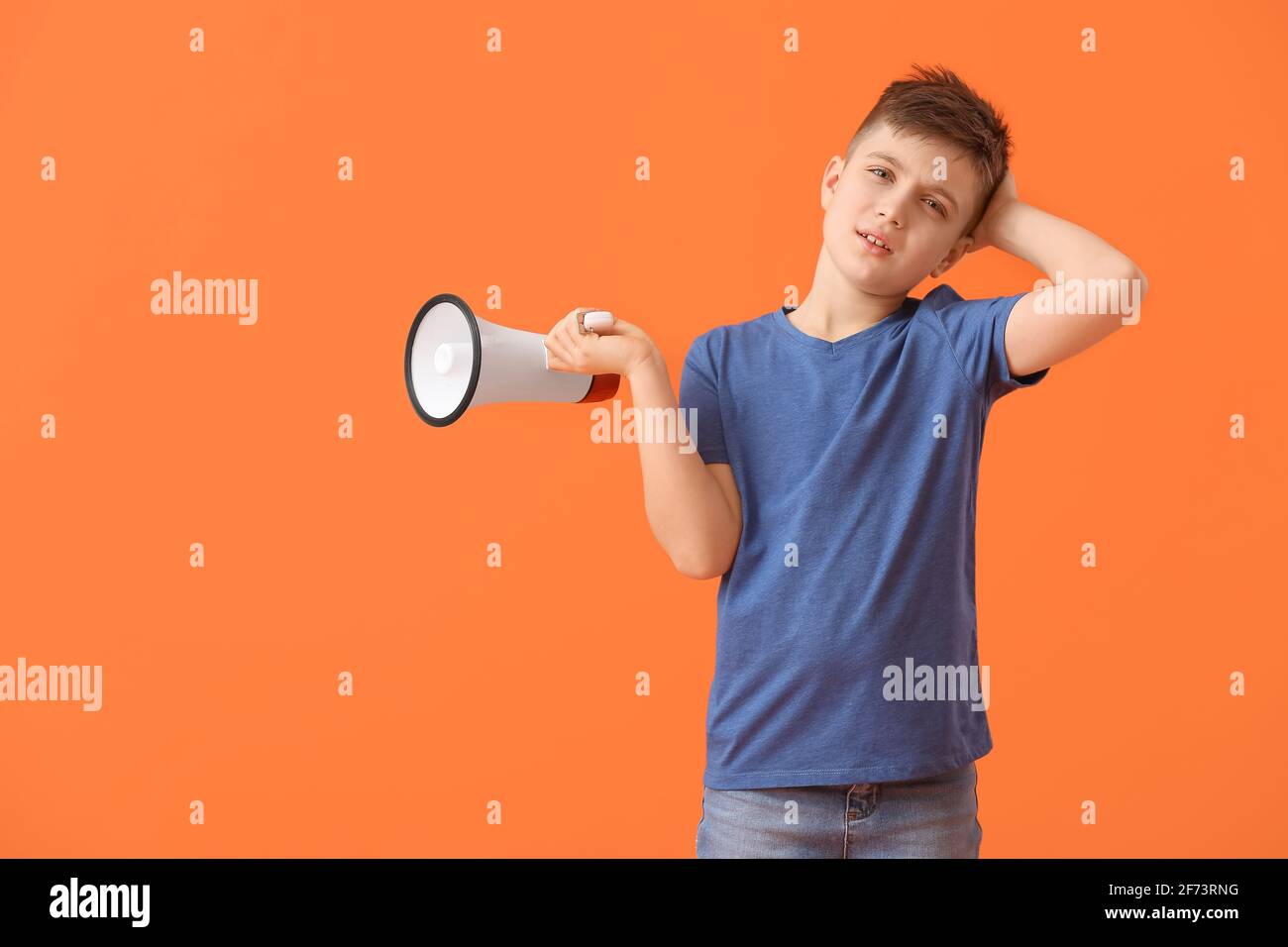 Confused little boy with megaphone on color background Stock Photo - Alamy