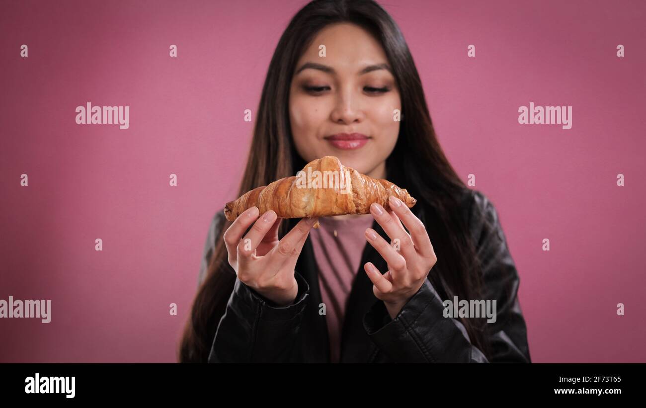 Young pretty woman eats a French croissant Stock Photo - Alamy