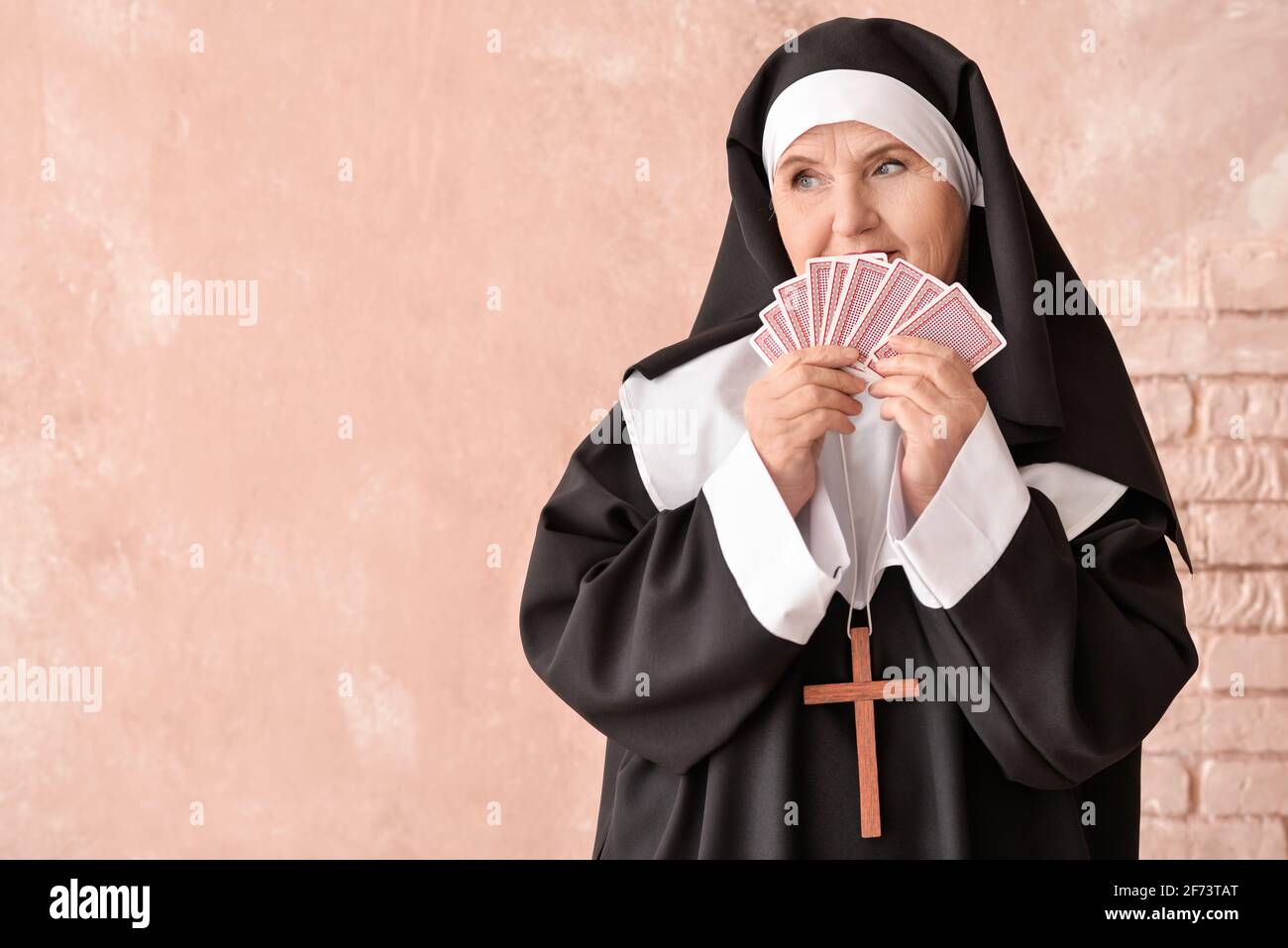 Senior nun with cards on color background Stock Photo - Alamy