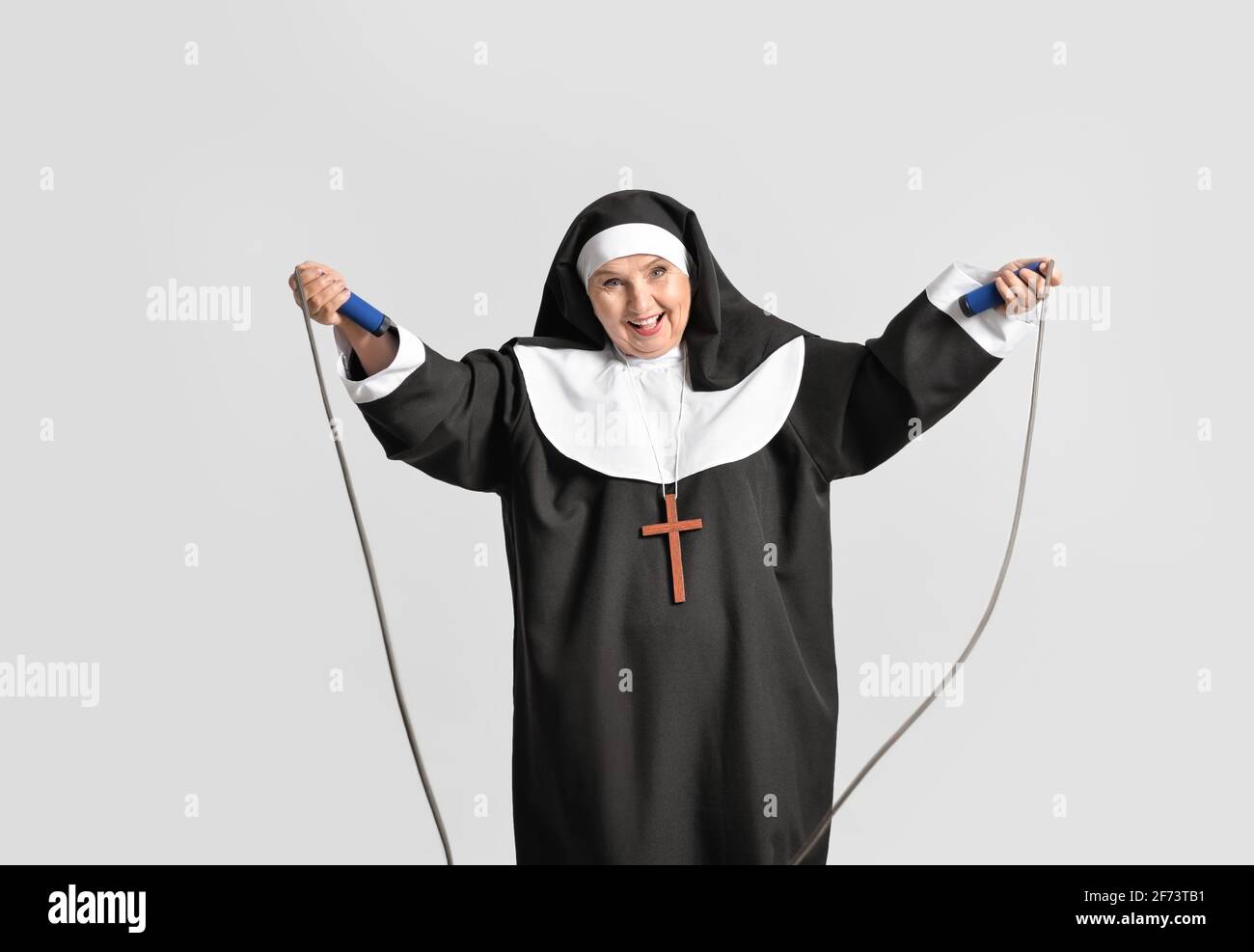 Senior nun with jumping rope on light background Stock Photo - Alamy