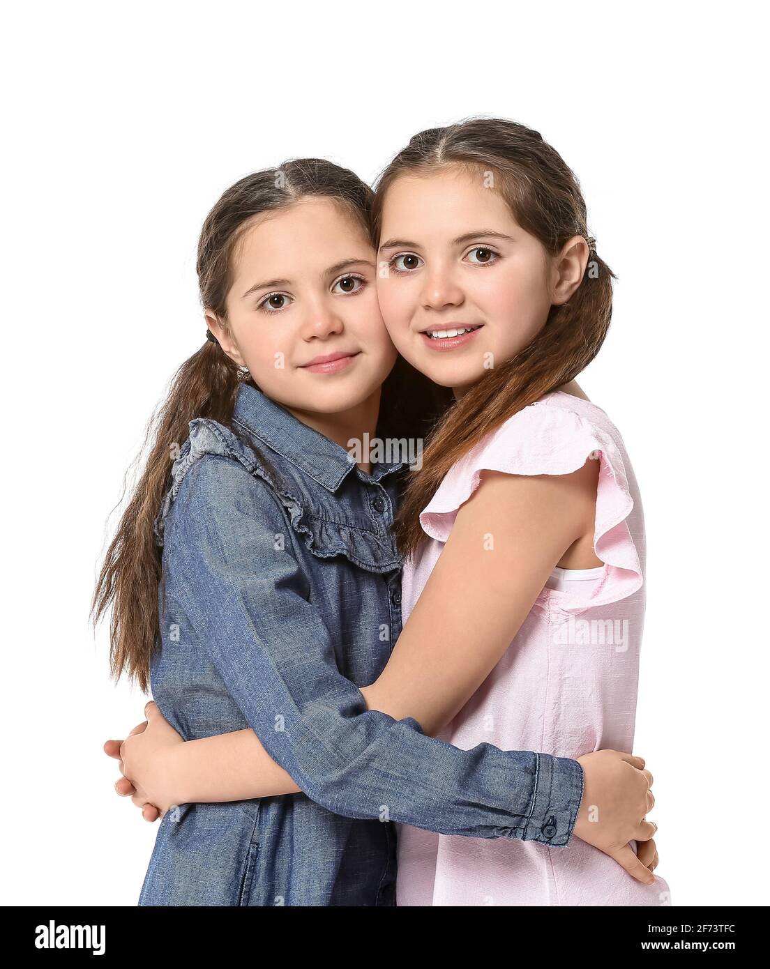 Portrait of cute twin girls on white background Stock Photo - Alamy