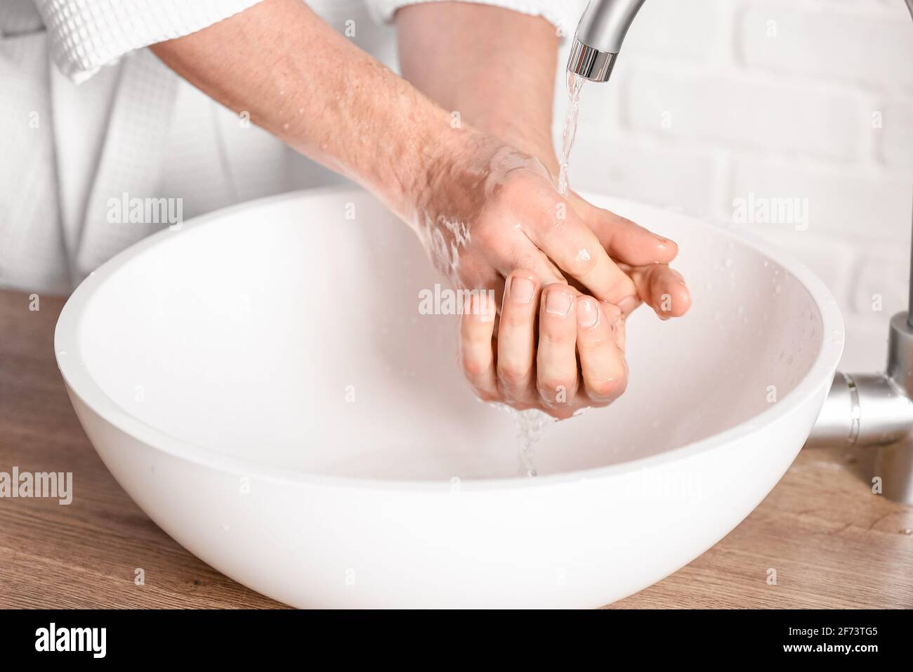 Man washing hands in bathroom Stock Photo - Alamy