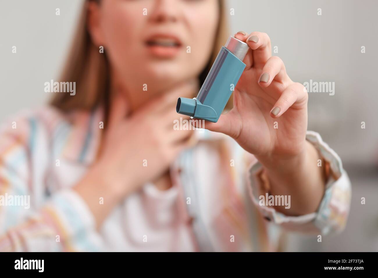 Young woman with inhaler having asthma attack at home Stock Photo - Alamy