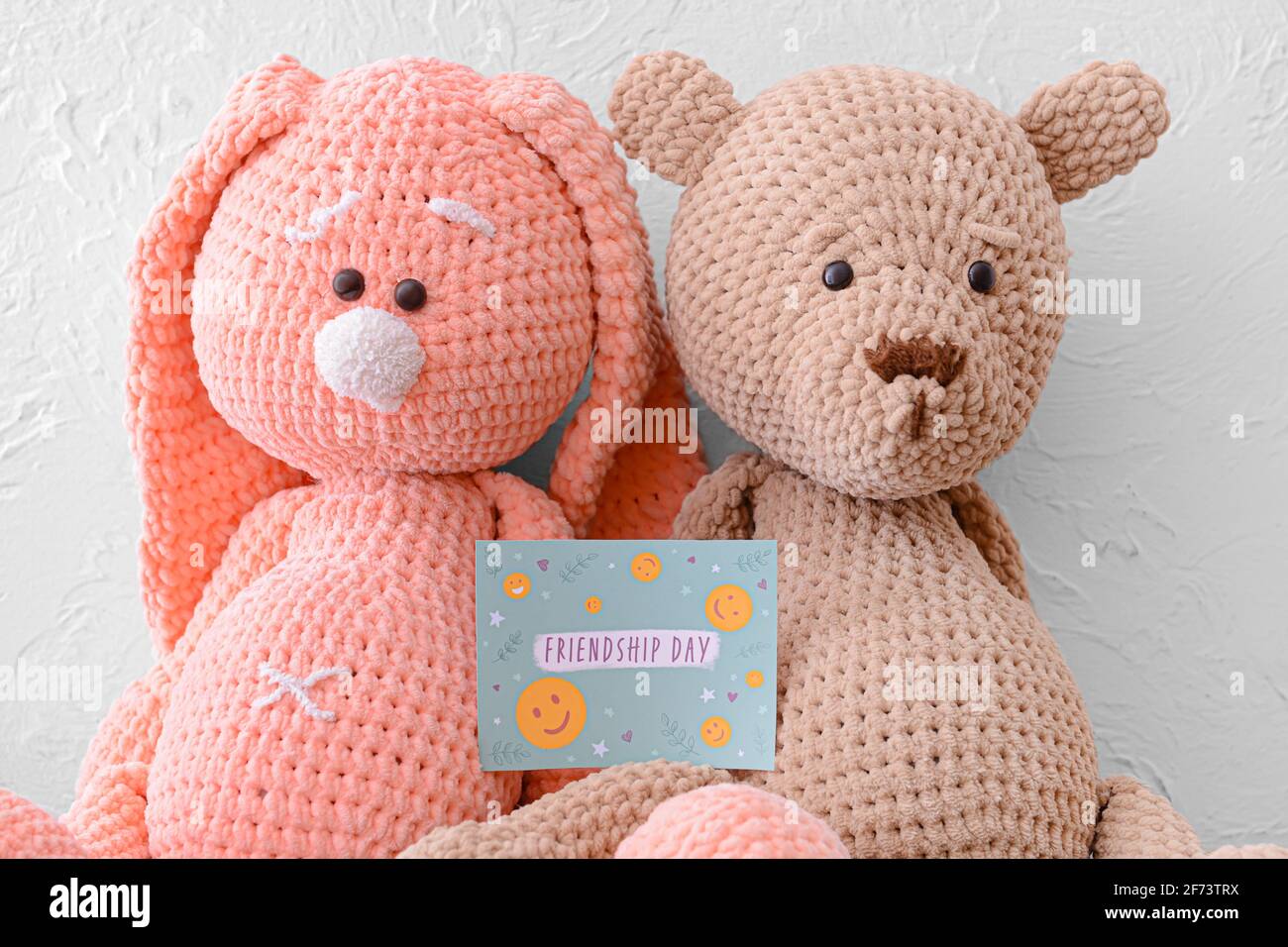 Cuddly toys and greeting card for Friendship Day on white background ...