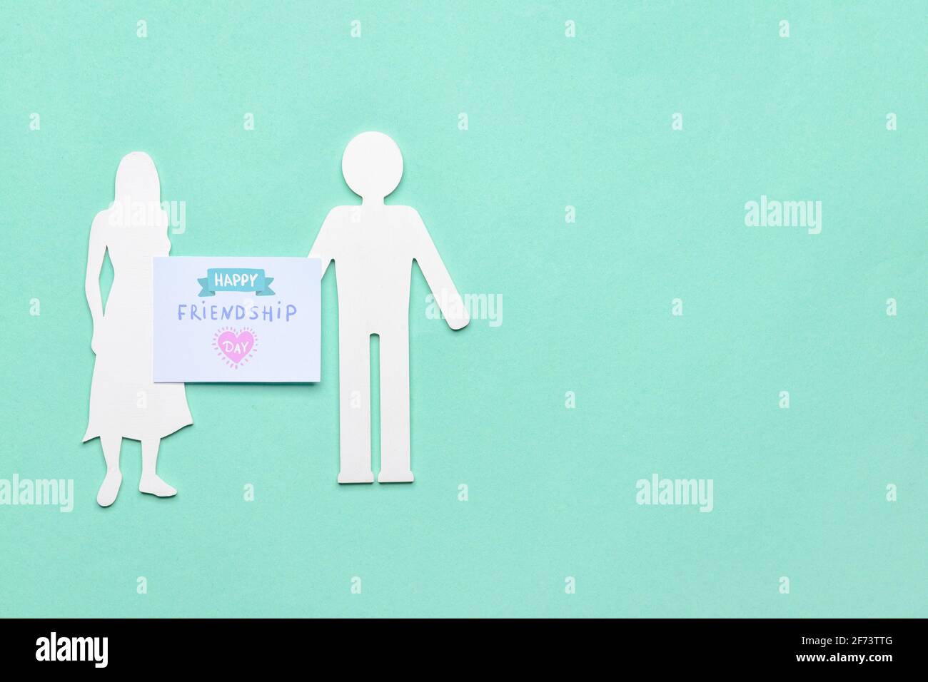 Paper human figures and greeting card for Friendship Day on color ...