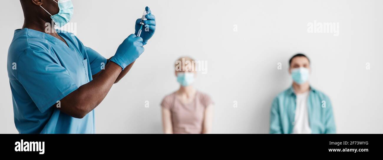 Diverse people waiting in line to get shots of Covid-19 infection at ...