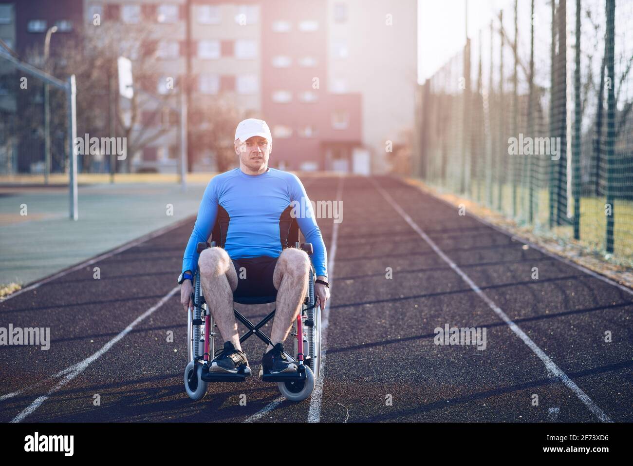 Disabled athlete in a wheelchair on a sports field, on a running track ...