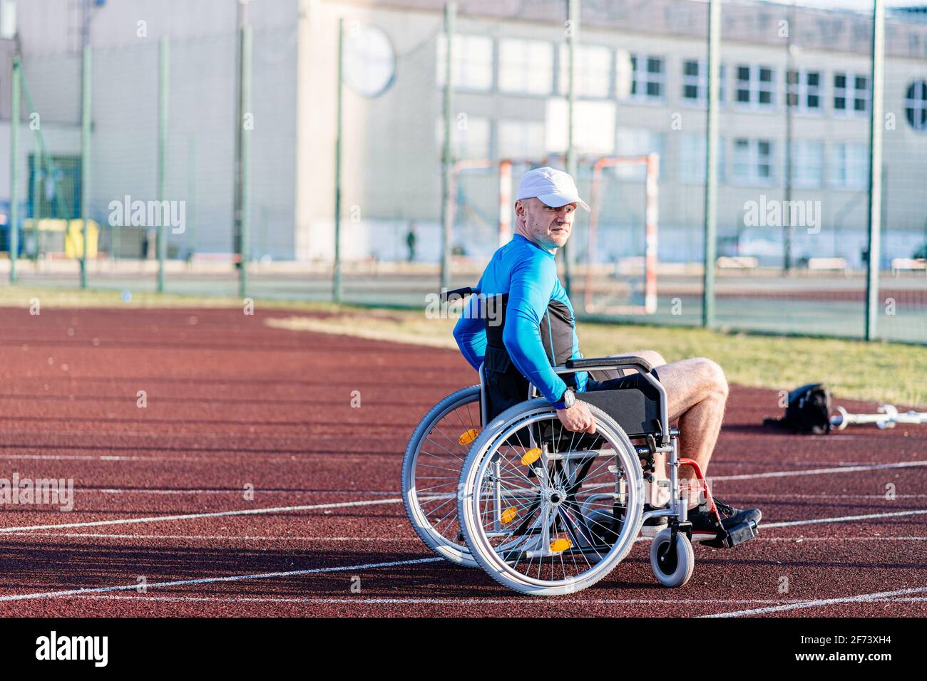 Smiling disabled athlete in a wheelchair on a sports field, on a ...