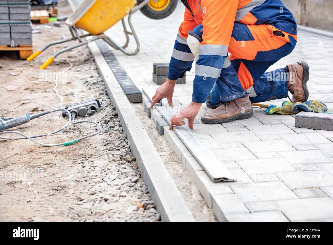 A worker uses a black marker and a straight aluminum batten to measure ...