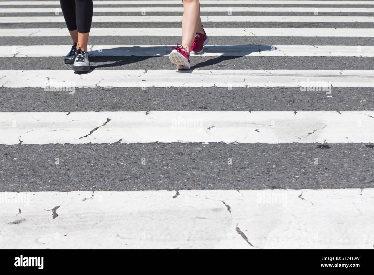 Pedestrian crossing city downtown girls walk in motion on road. Legs ...