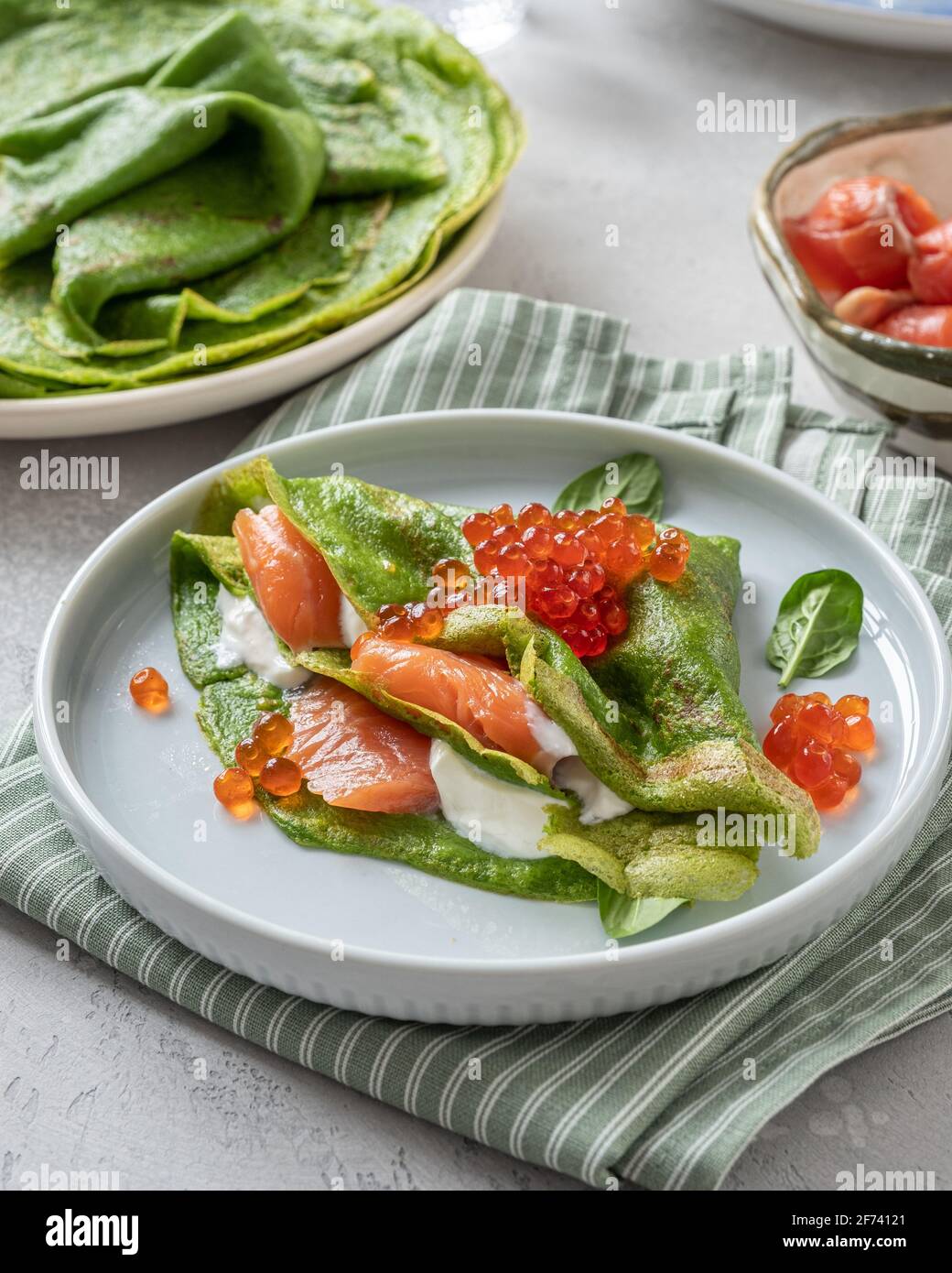 Green spinach crepes with smoked salmon, red caviar and yogurt sauce ...