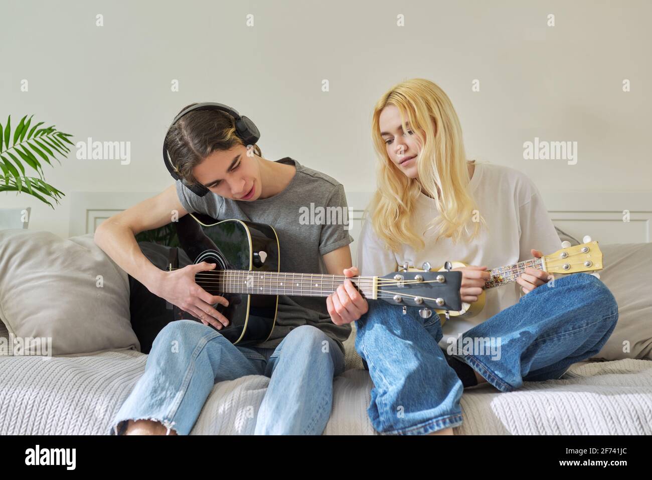 Creative teenagers friends with musical instruments, acoustic guitar ...