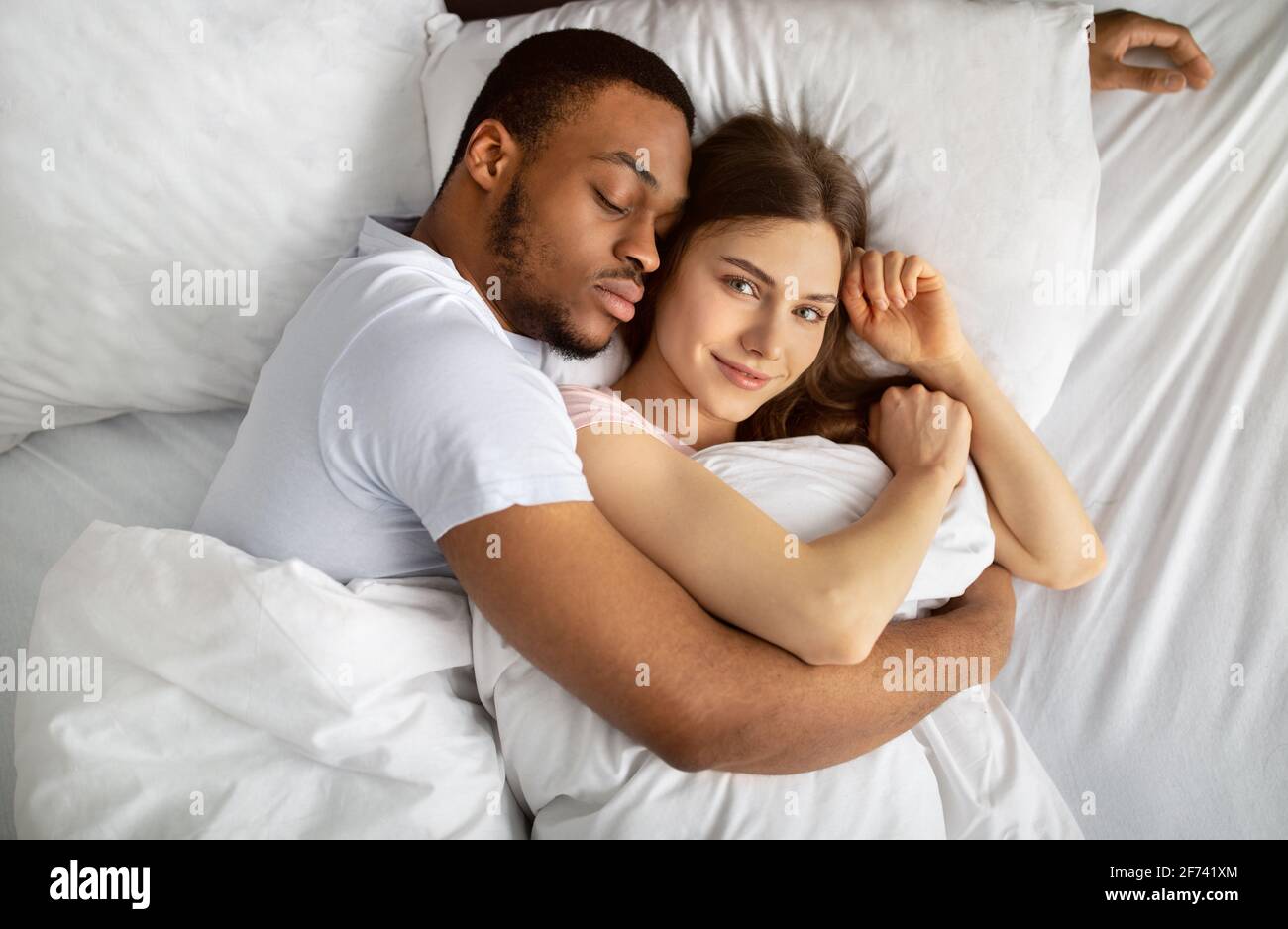 Black Man And Woman Cuddling In Bed