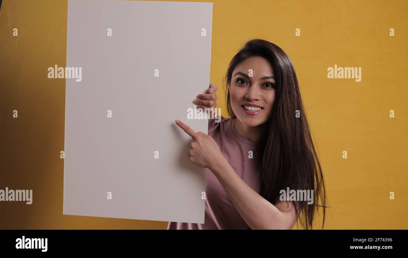 Young pretty woman points to a sign Stock Photo - Alamy