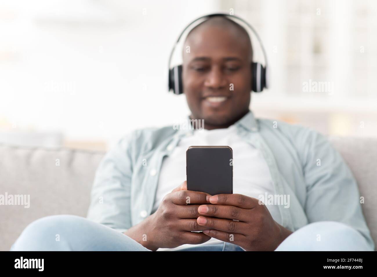 Music player application for smartphone. African american man listening ...