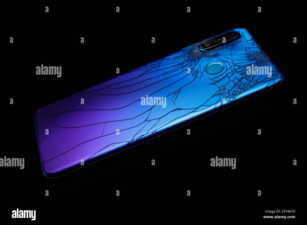 The back panel of a broken mobile phone. Damaged smartphone camera ...