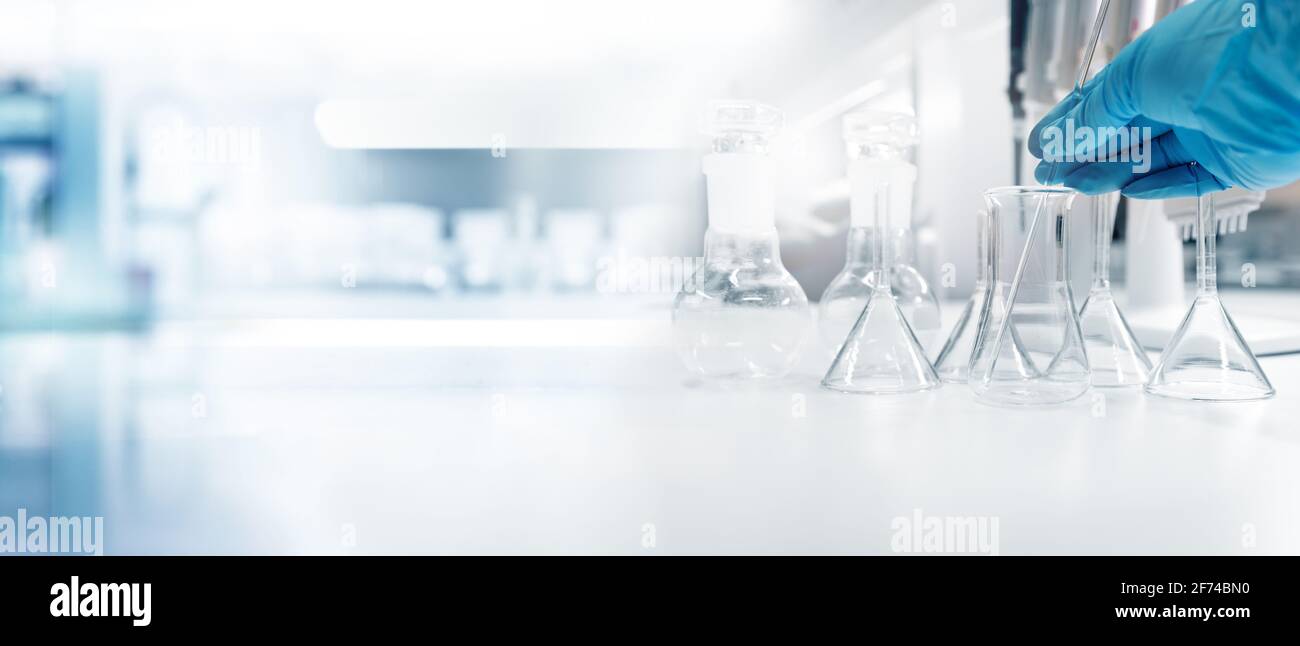 hand of scientist in blue glove with test tube and flask in medical ...