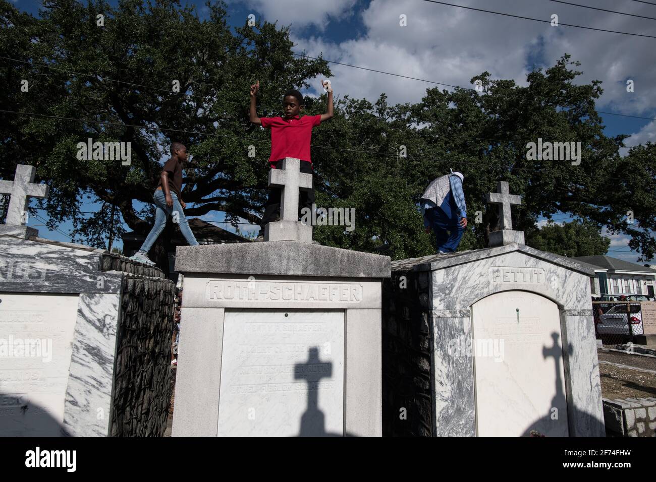 Young men dance atop tombs during a vibrant second line procession ...