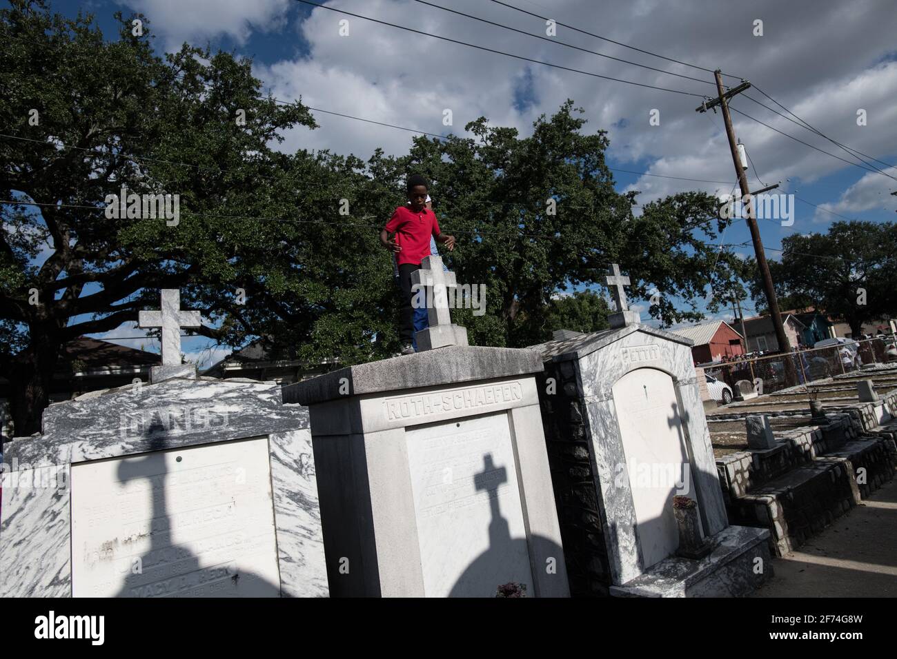 Young men dance atop tombs during a vibrant second line procession ...