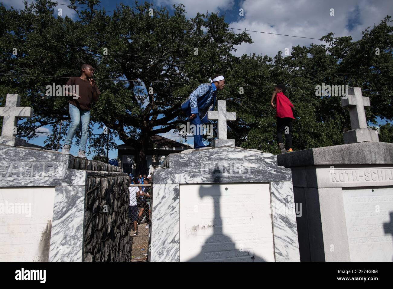 Young men dance atop tombs during a vibrant second line procession ...
