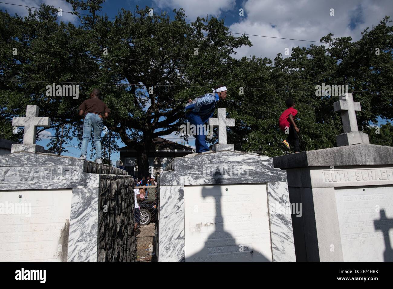 Young men dance atop tombs during a vibrant second line procession ...