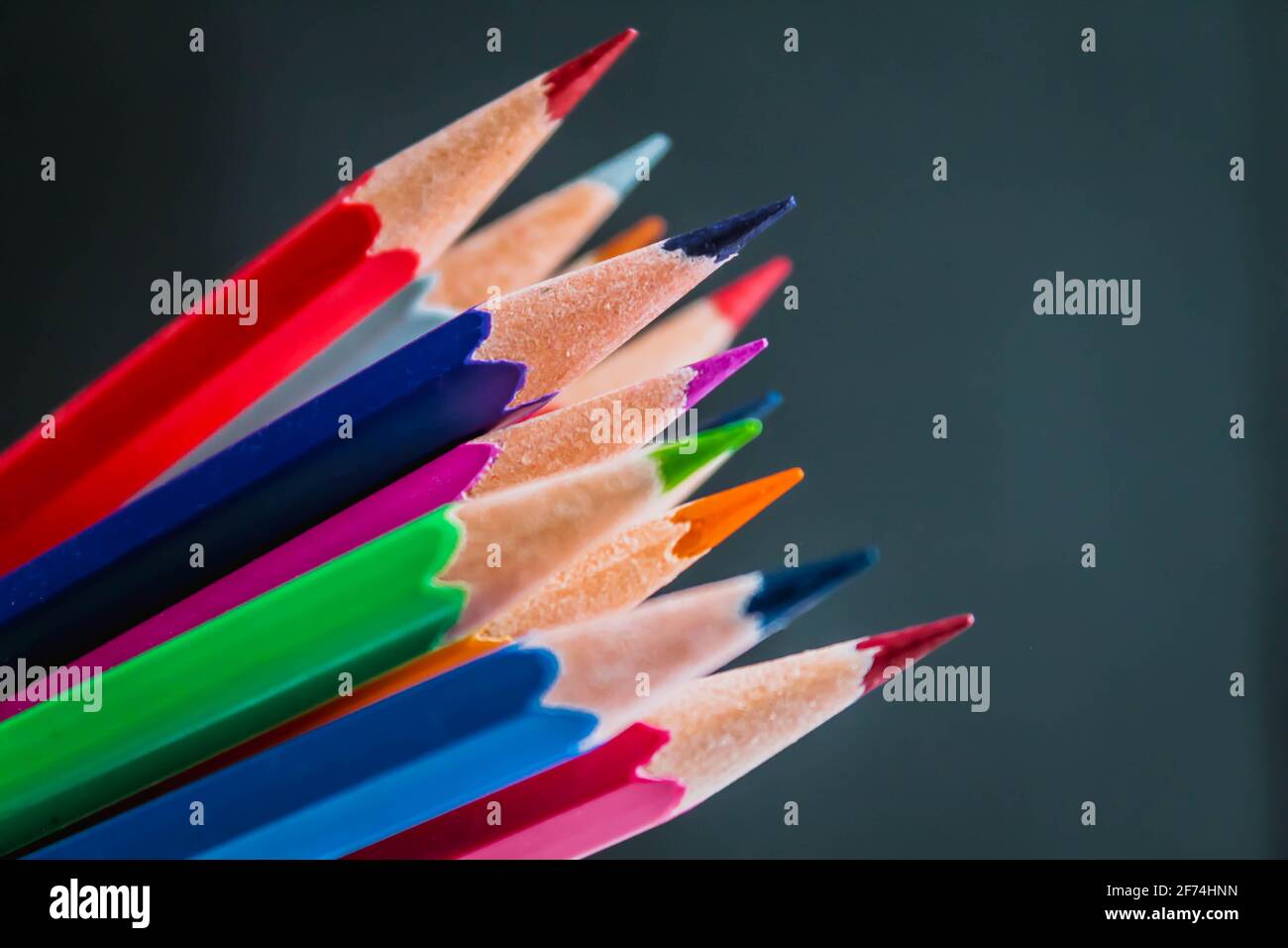 Tips of Colored pencils on black background. back to school. copy space ...