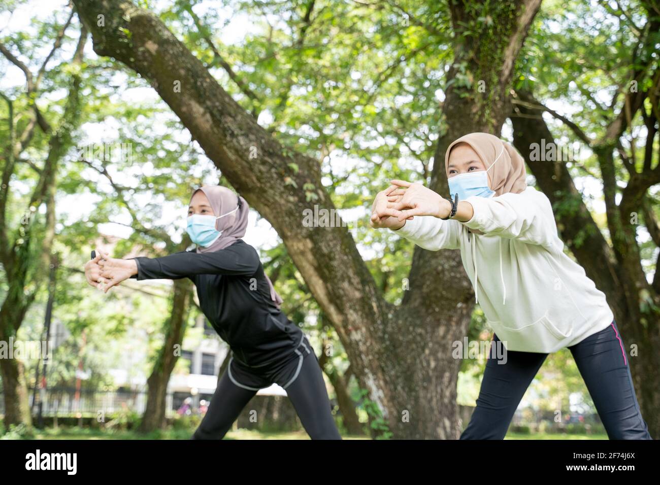 muslim woman with mask stretching her body outdoor exercise Stock Photo ...