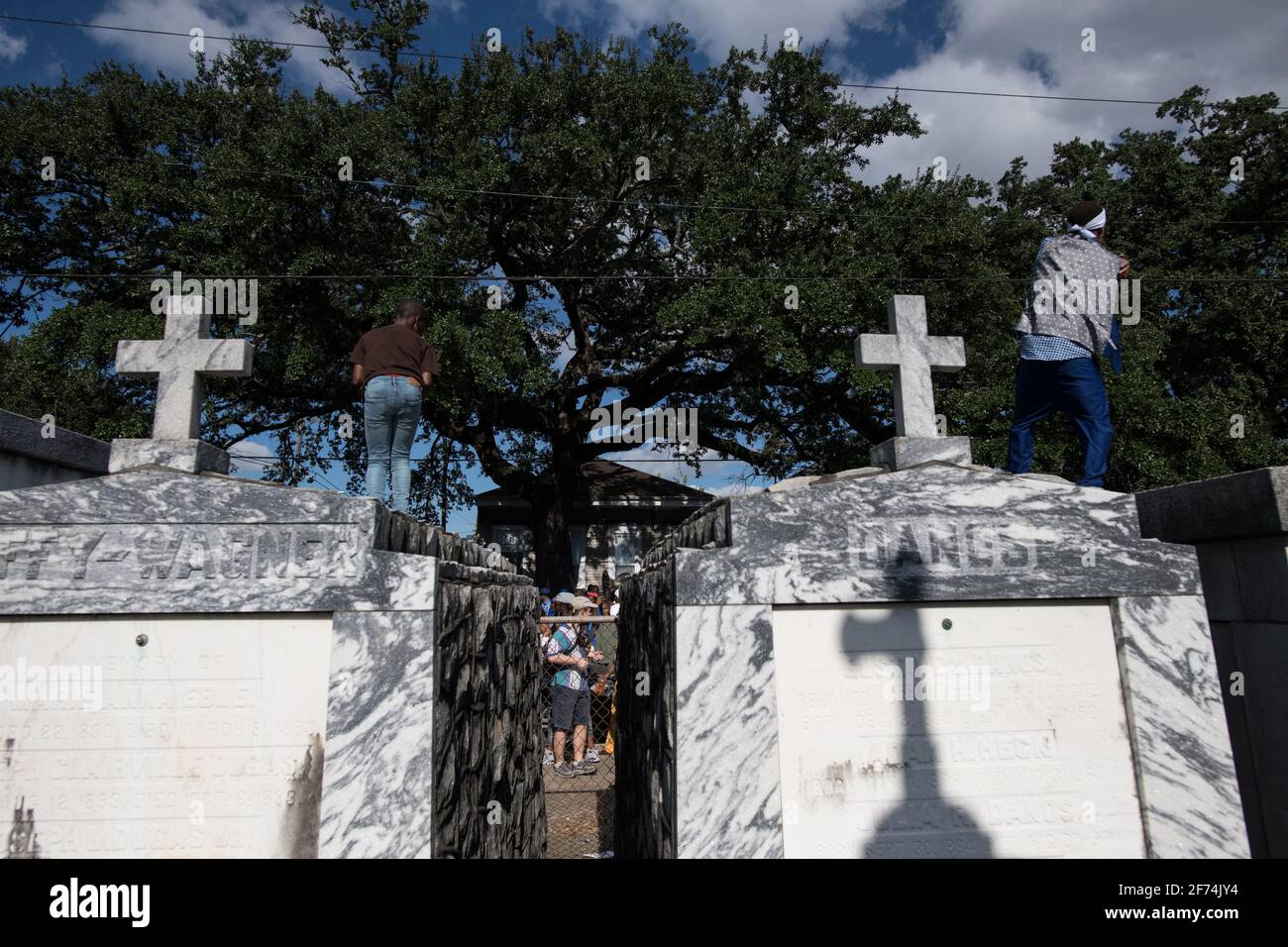 Young men dance atop tombs during a vibrant second line procession ...