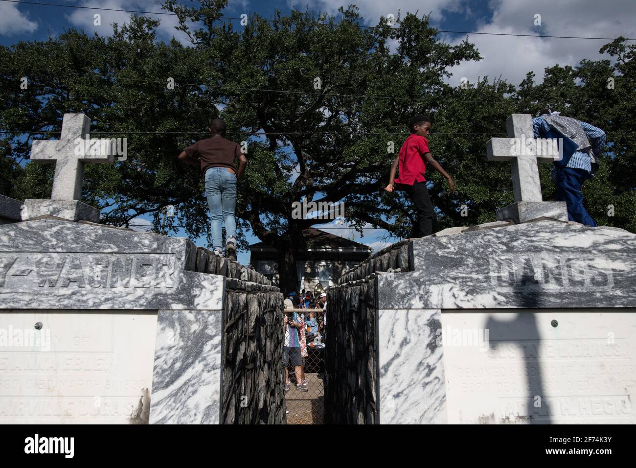 Young men dance atop tombs during a vibrant second line procession ...
