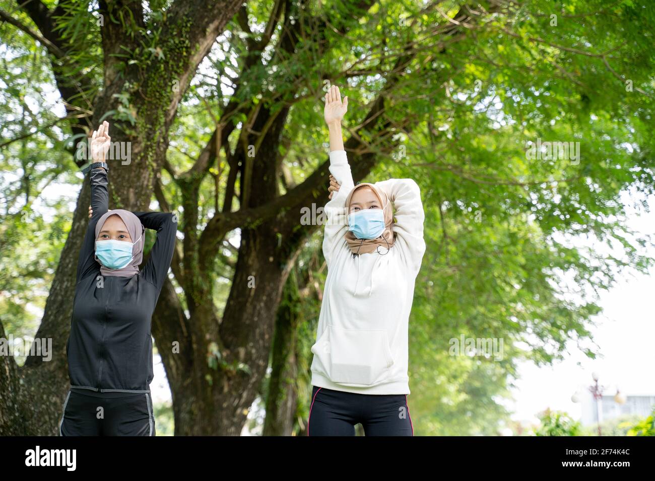 muslim woman with mask stretching her body outdoor exercise Stock Photo ...
