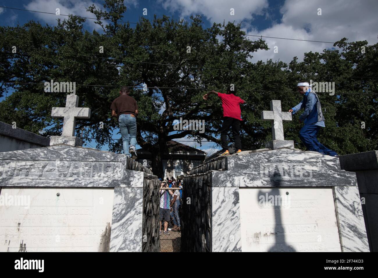 Young men dance atop tombs during a vibrant second line procession ...