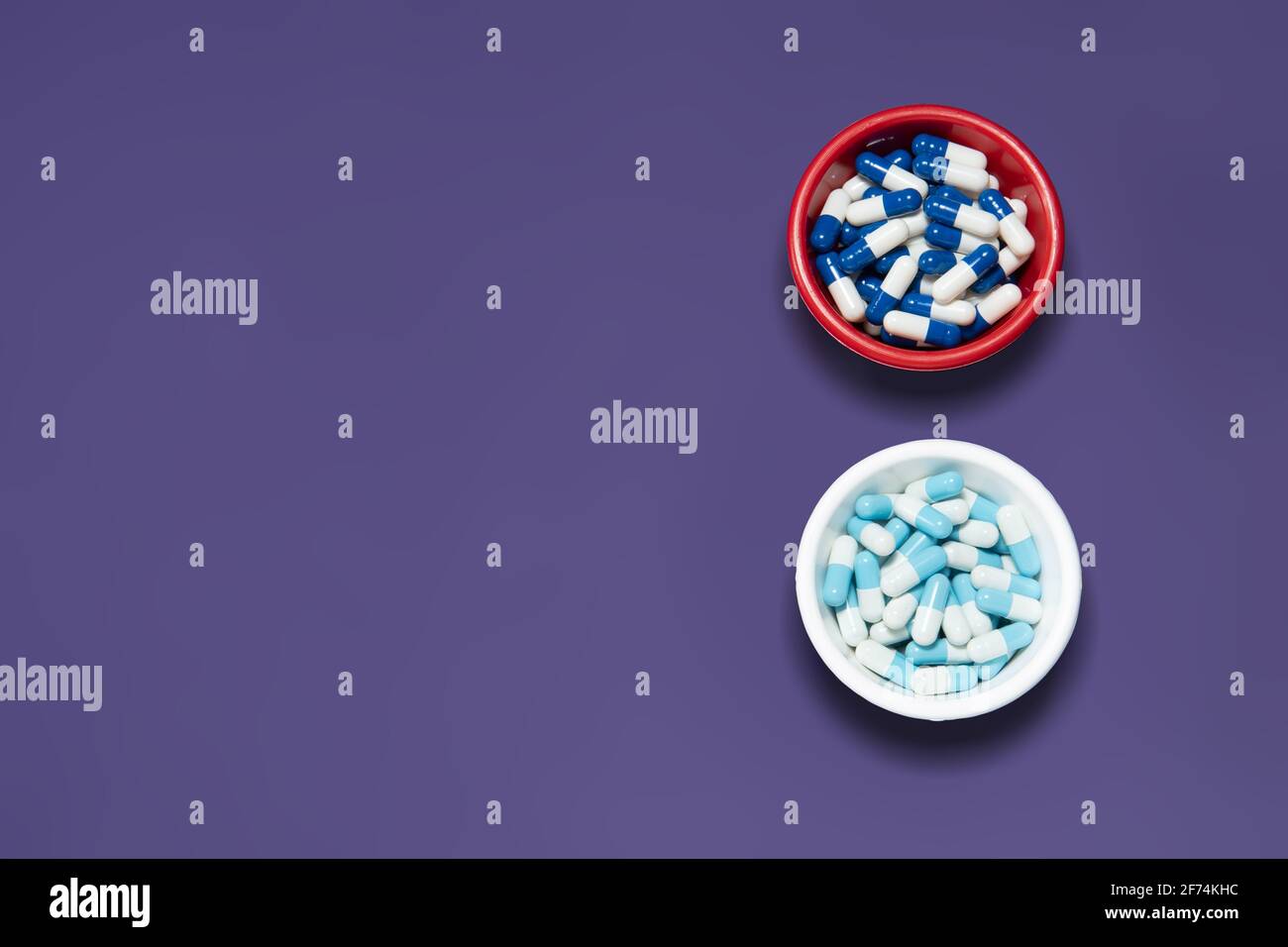 Pharmaceutical medicine pill capsules, in plastic bowl on colorful dark ...
