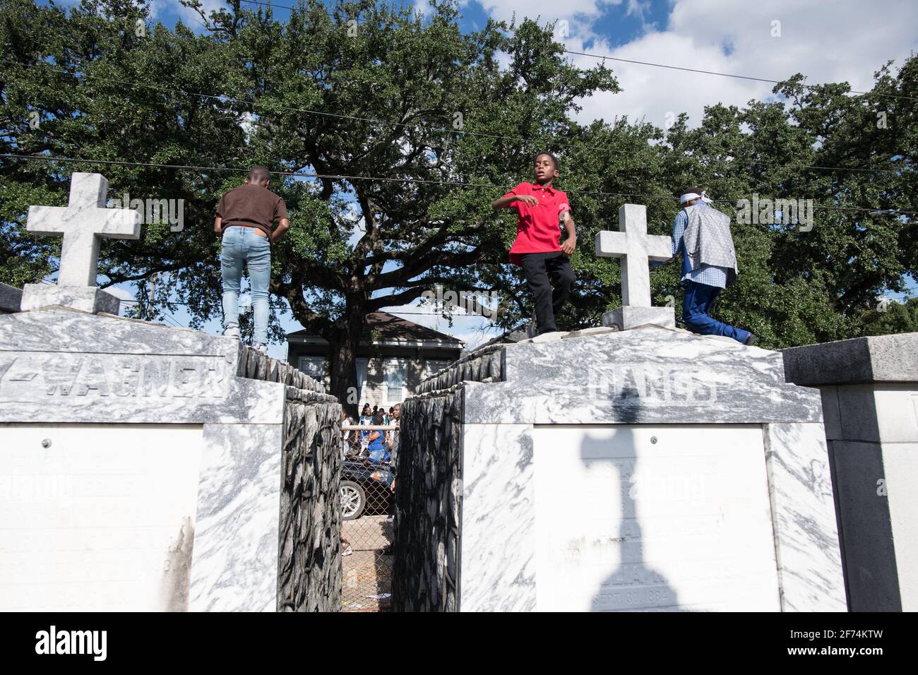 Young men dance atop tombs during a vibrant second line procession ...