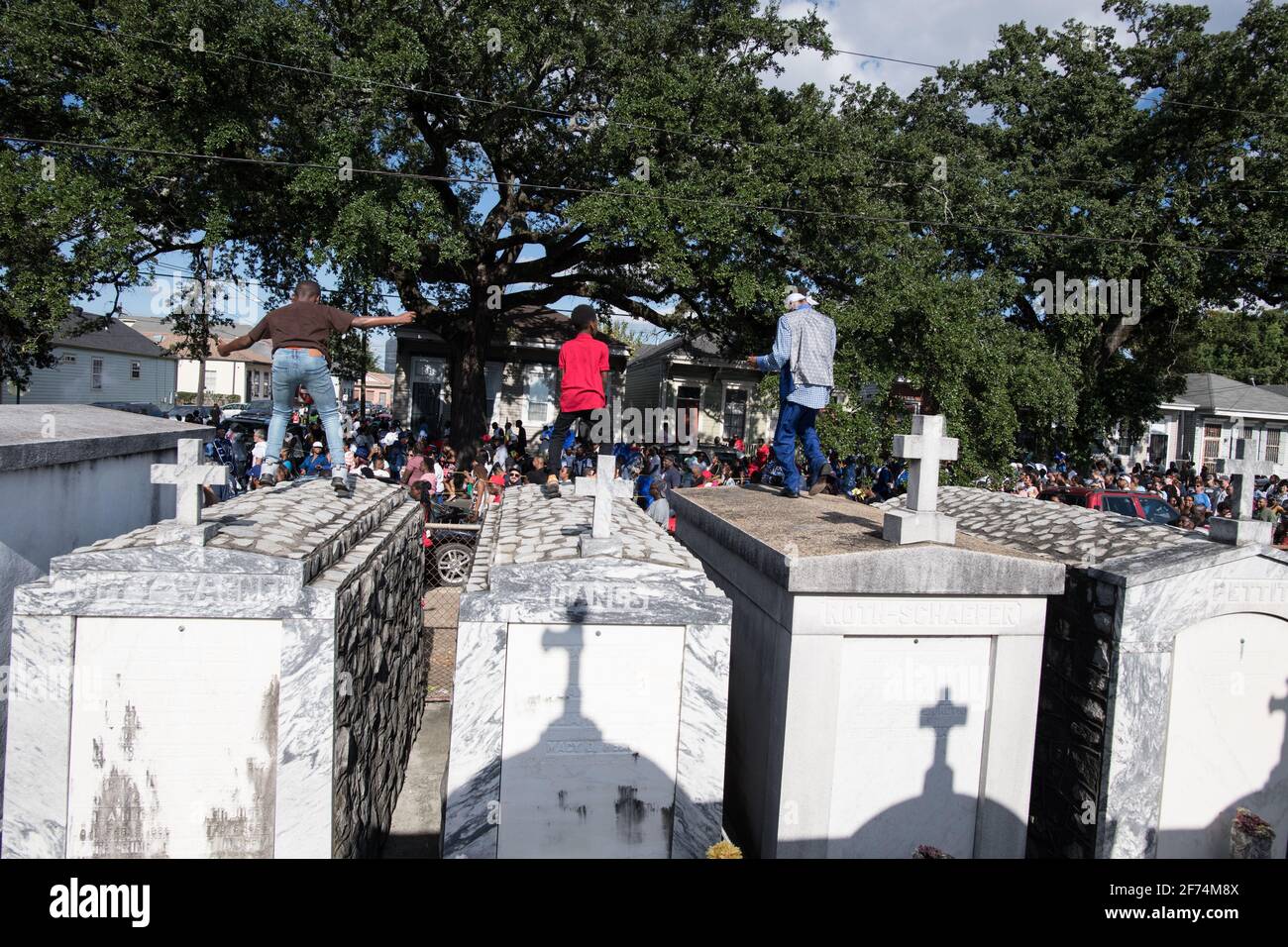Young men dance atop tombs during a vibrant second line procession ...