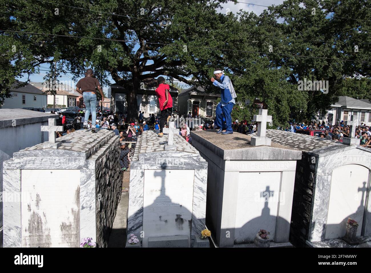 Young men dance atop tombs during a vibrant second line procession ...