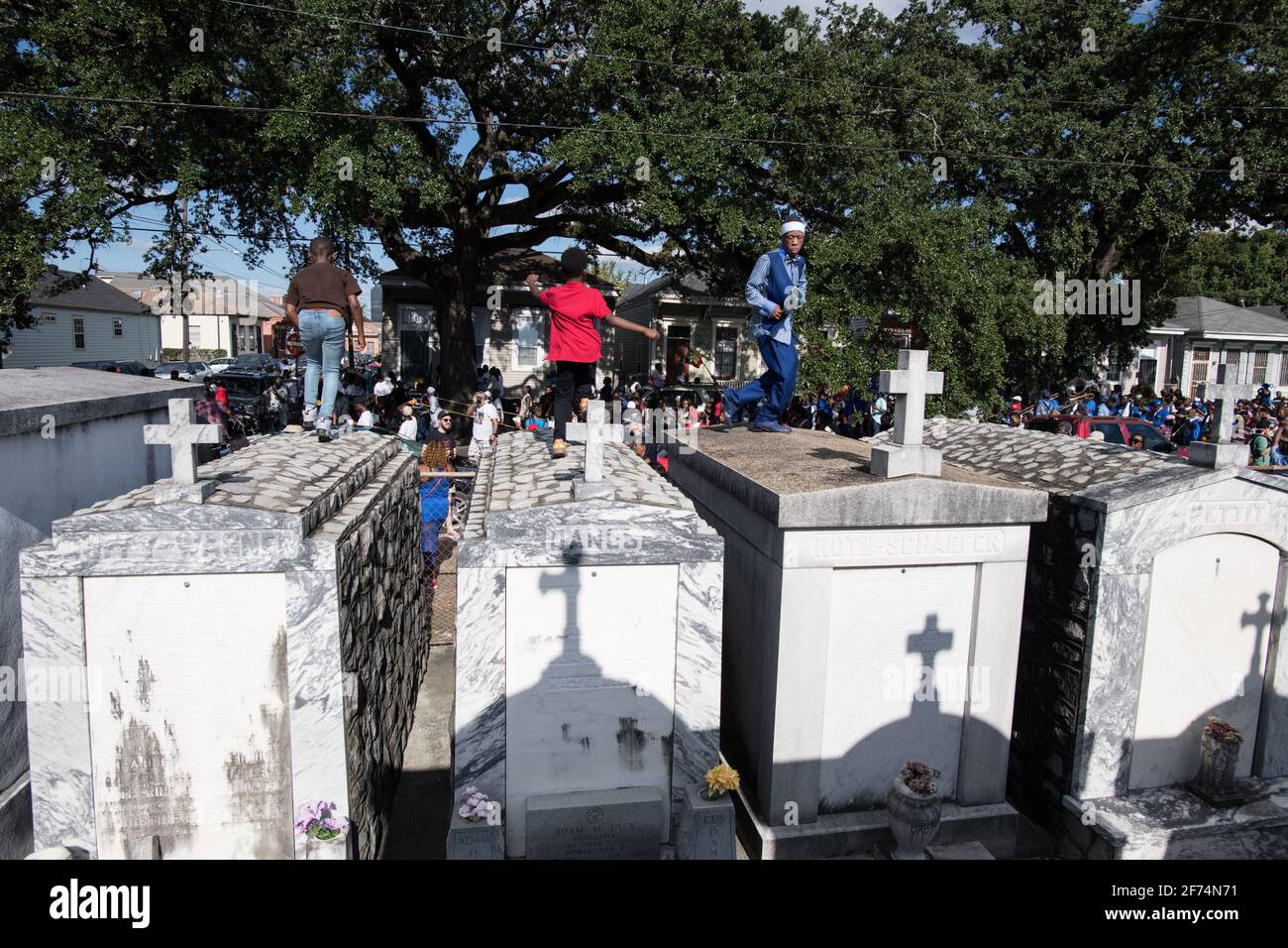 Young men dance atop tombs during a vibrant second line procession ...