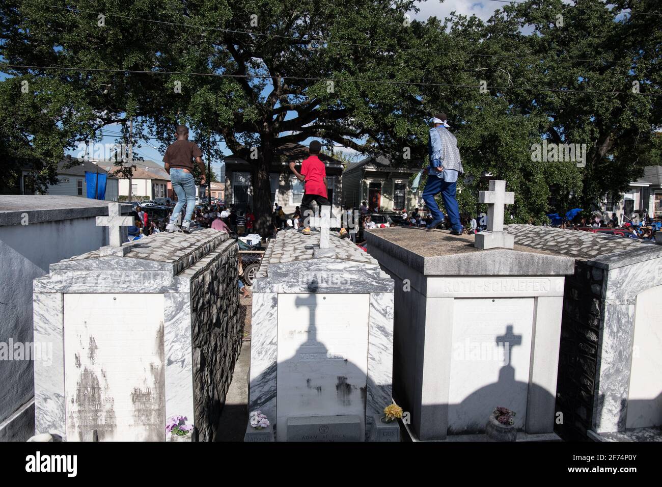 Young men dance atop tombs during a vibrant second line procession ...
