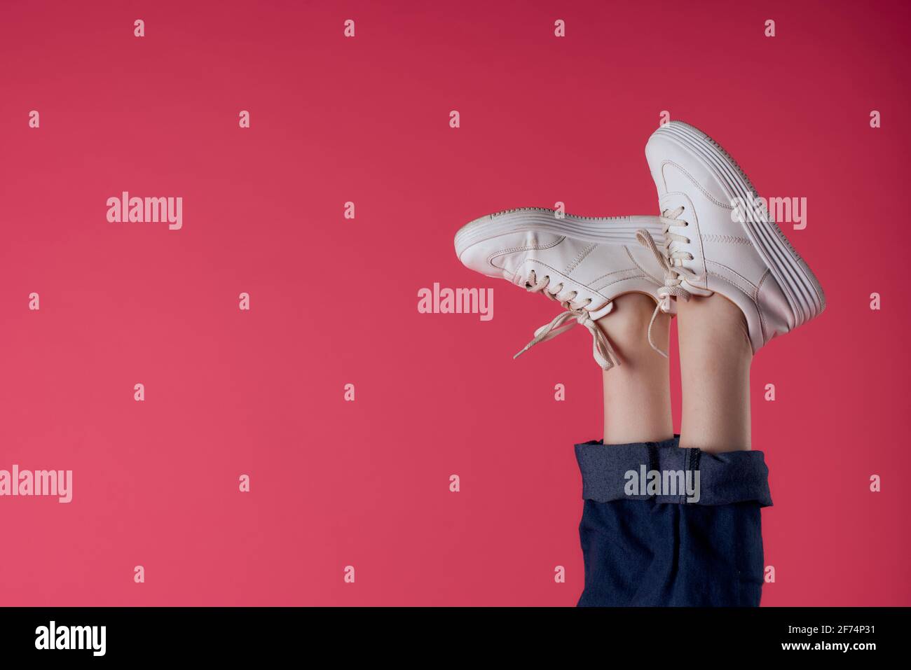 White sneakers upside down legs movement street fashion pink background ...
