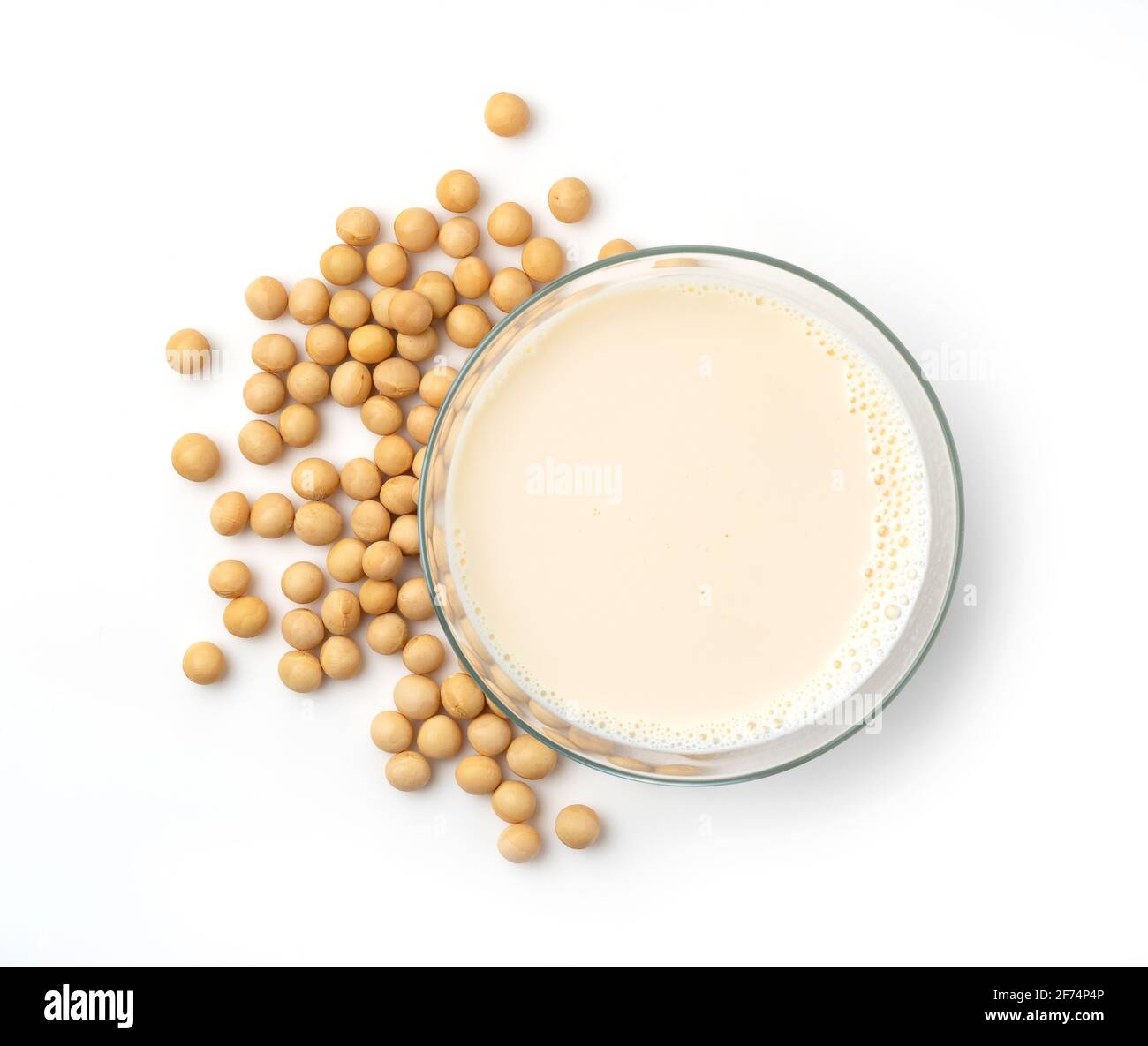 Soy milk and soybeans in a glass on a white background. View from above ...