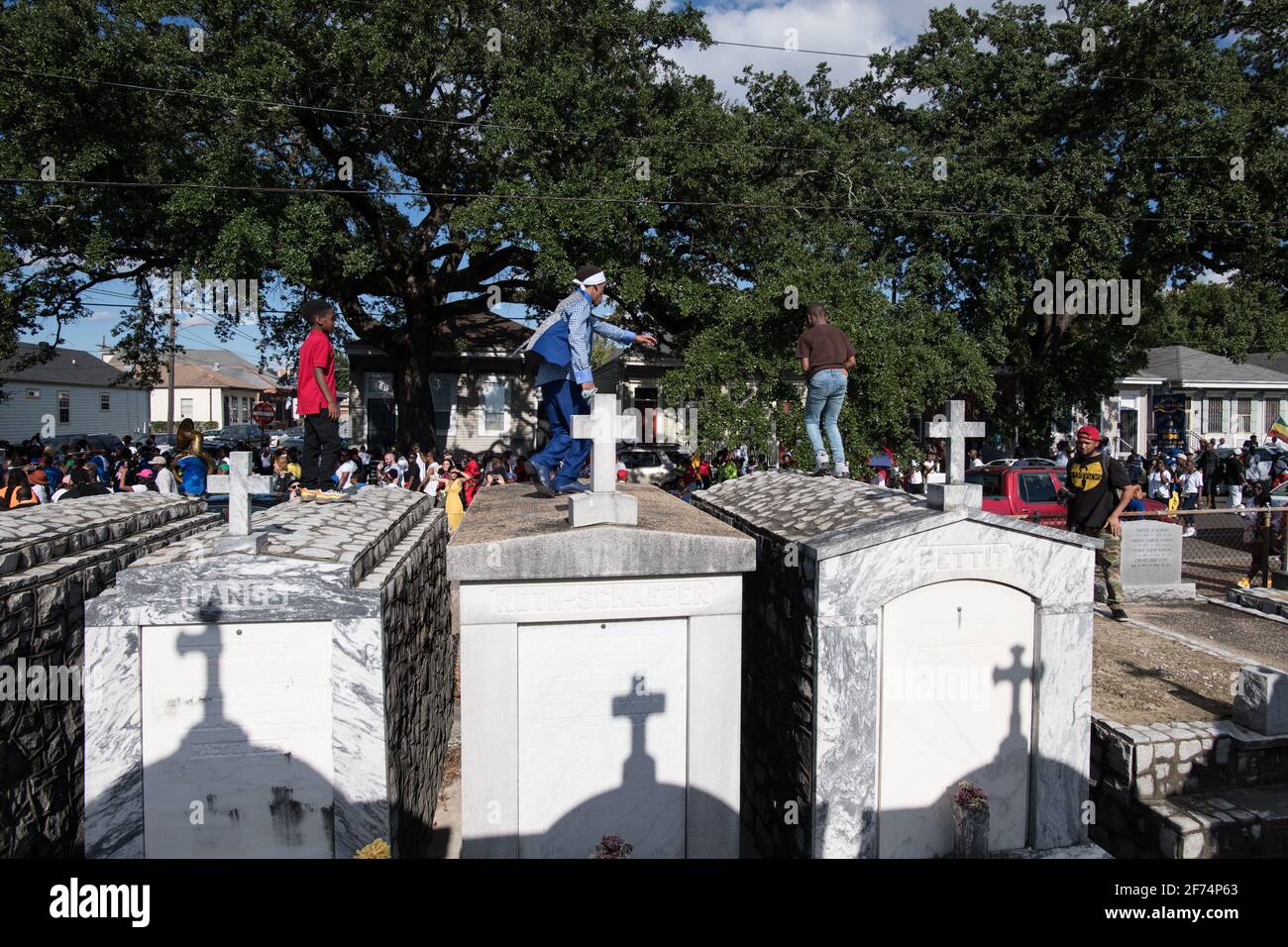 Young men dance atop tombs during a vibrant second line procession ...