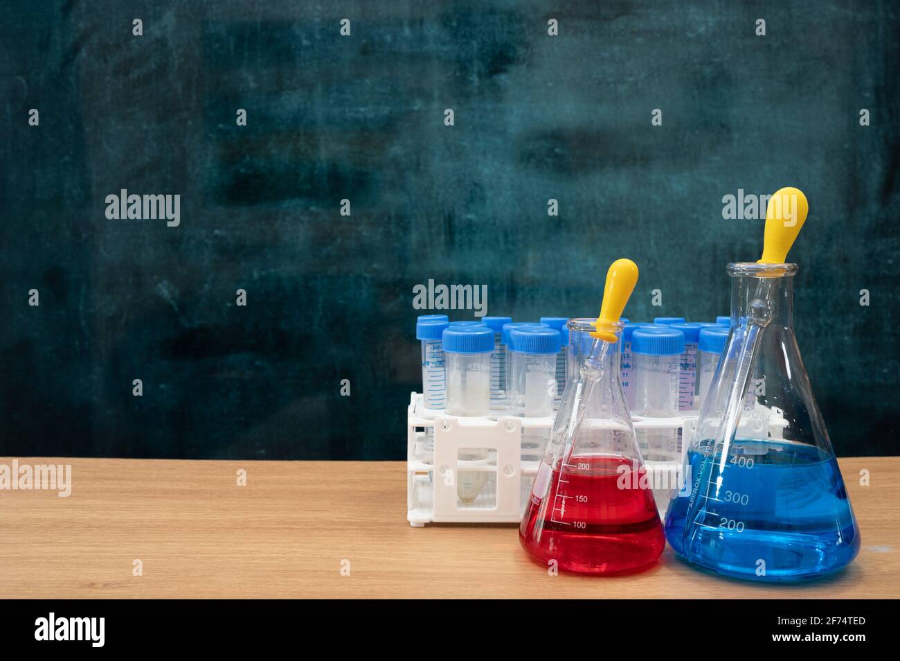 Scientific experiment tools on the desk. Empty blackboard. Education ...