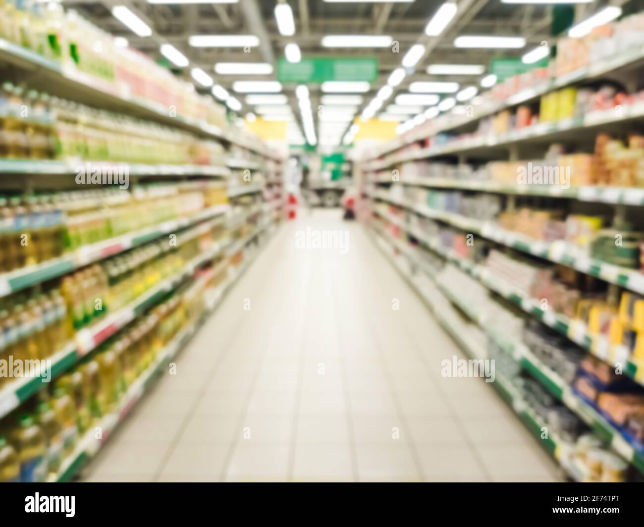 Blurred supermarket aisle with colorful shelves of merchandise ...