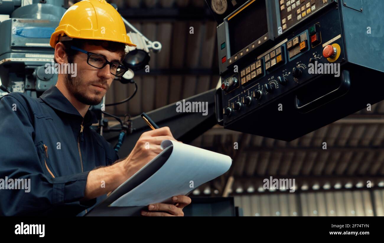 Skillful factory worker working with clipboard to do job procedure ...