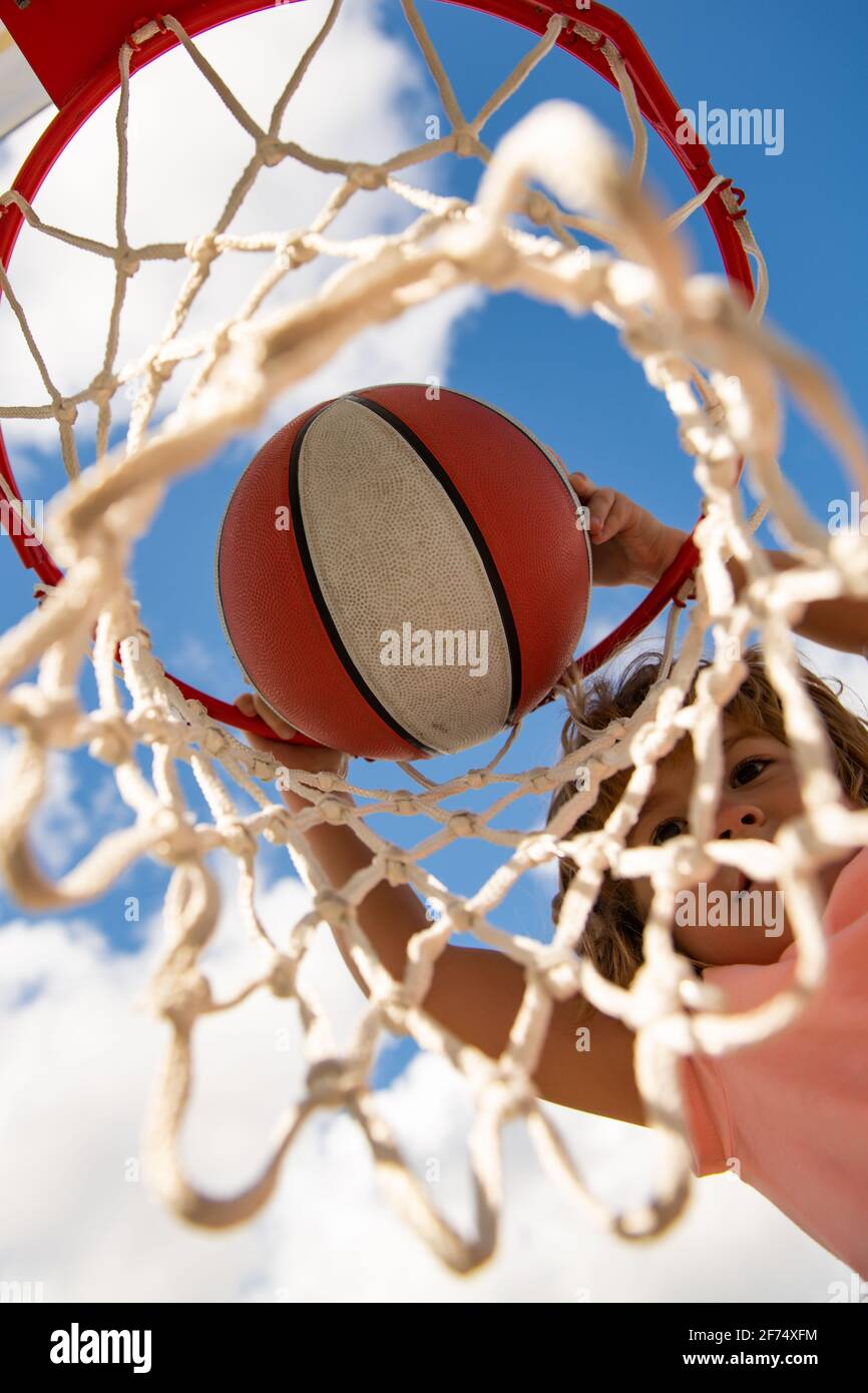 Kid playing basketball. View of flying ball to basket from top, kid ...