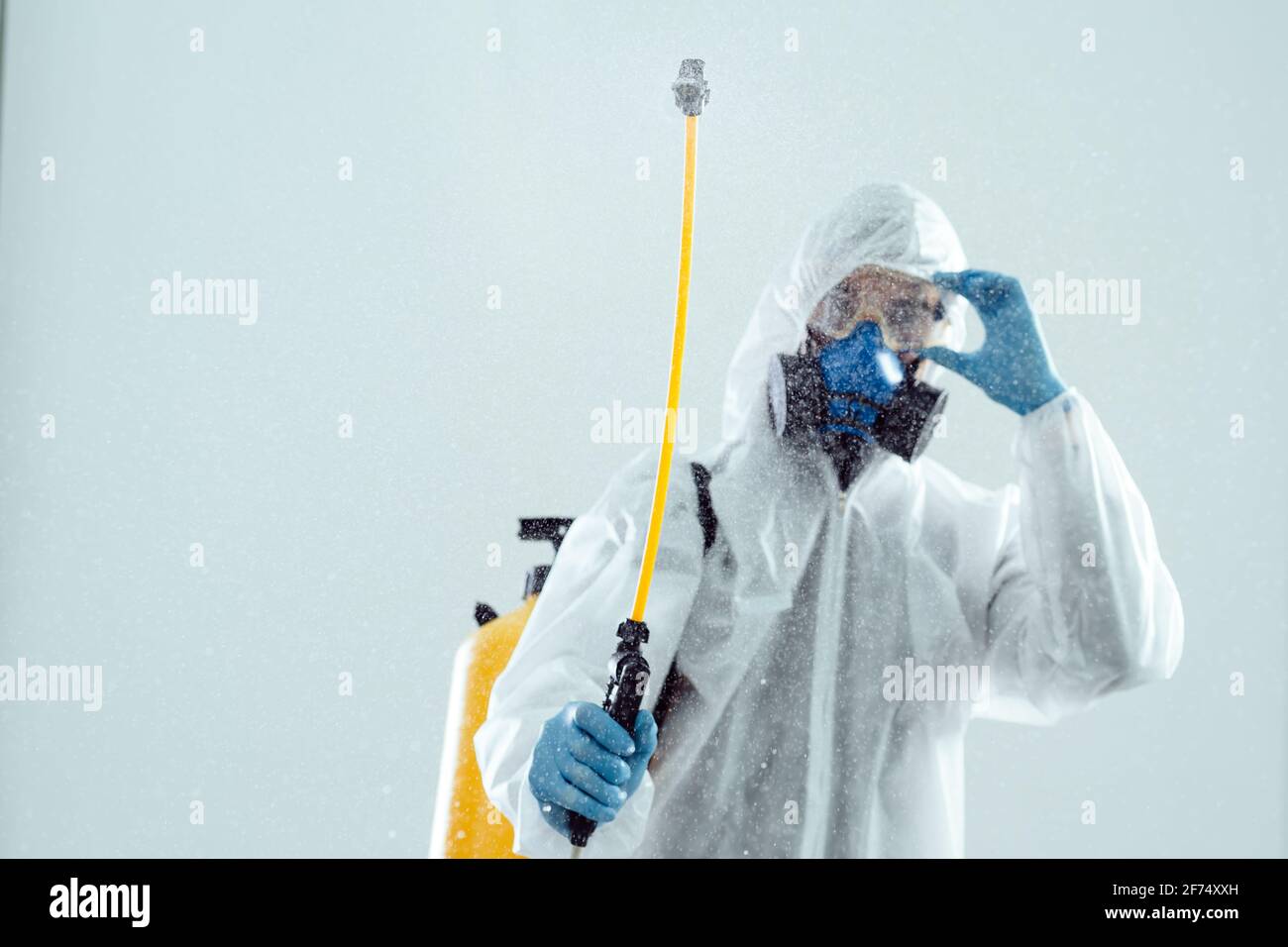 image of a spray gun in the hands of an employee of the sanitary ...