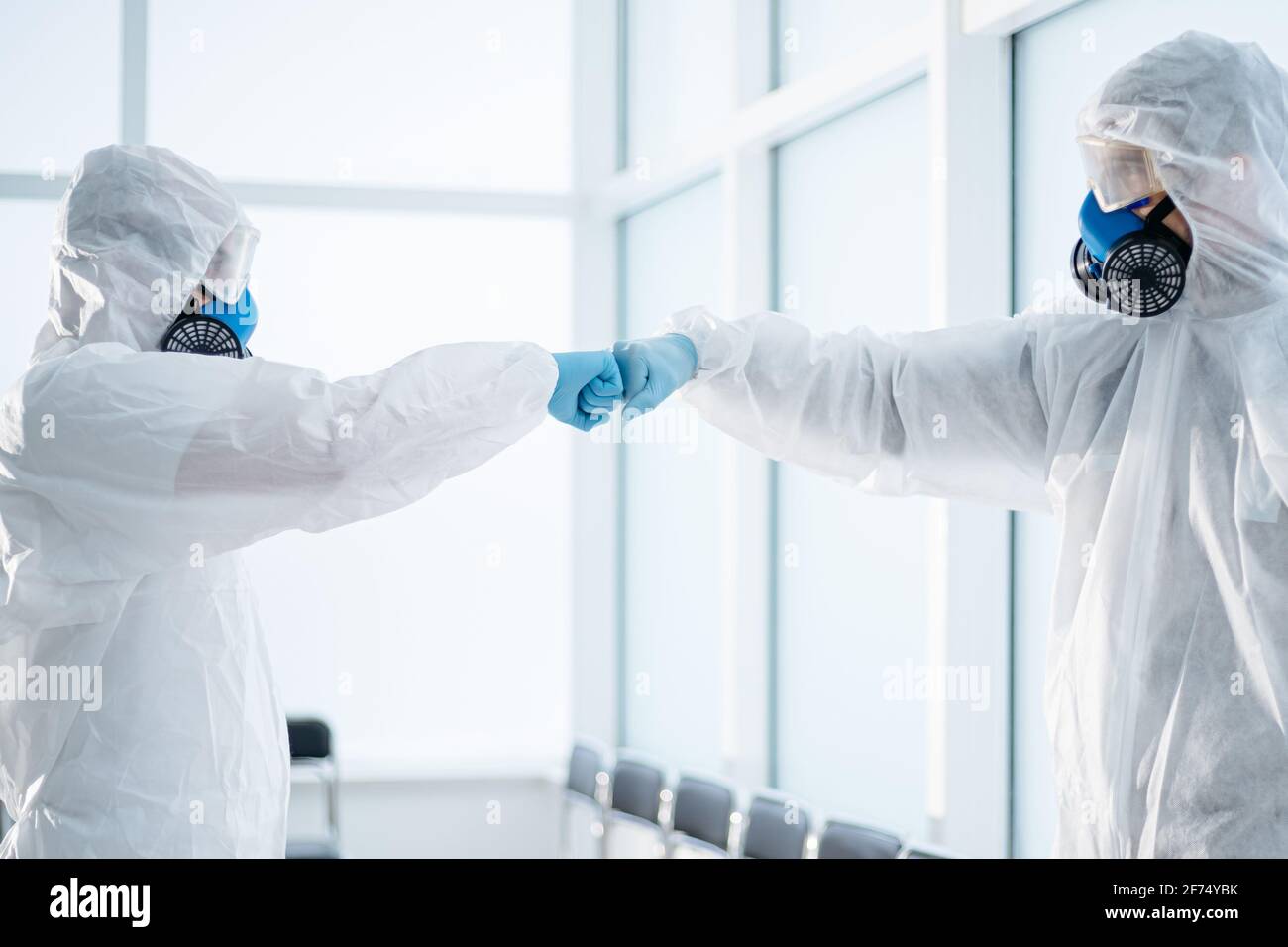 people in biohazard suits greeting each other Stock Photo - Alamy