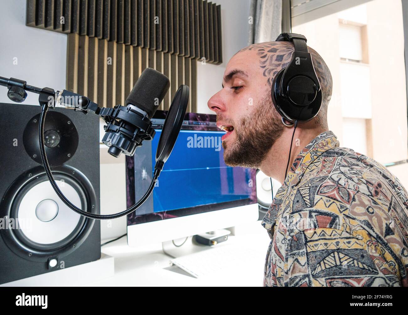 Side view man musician in stylish clothes in headphones standing and ...