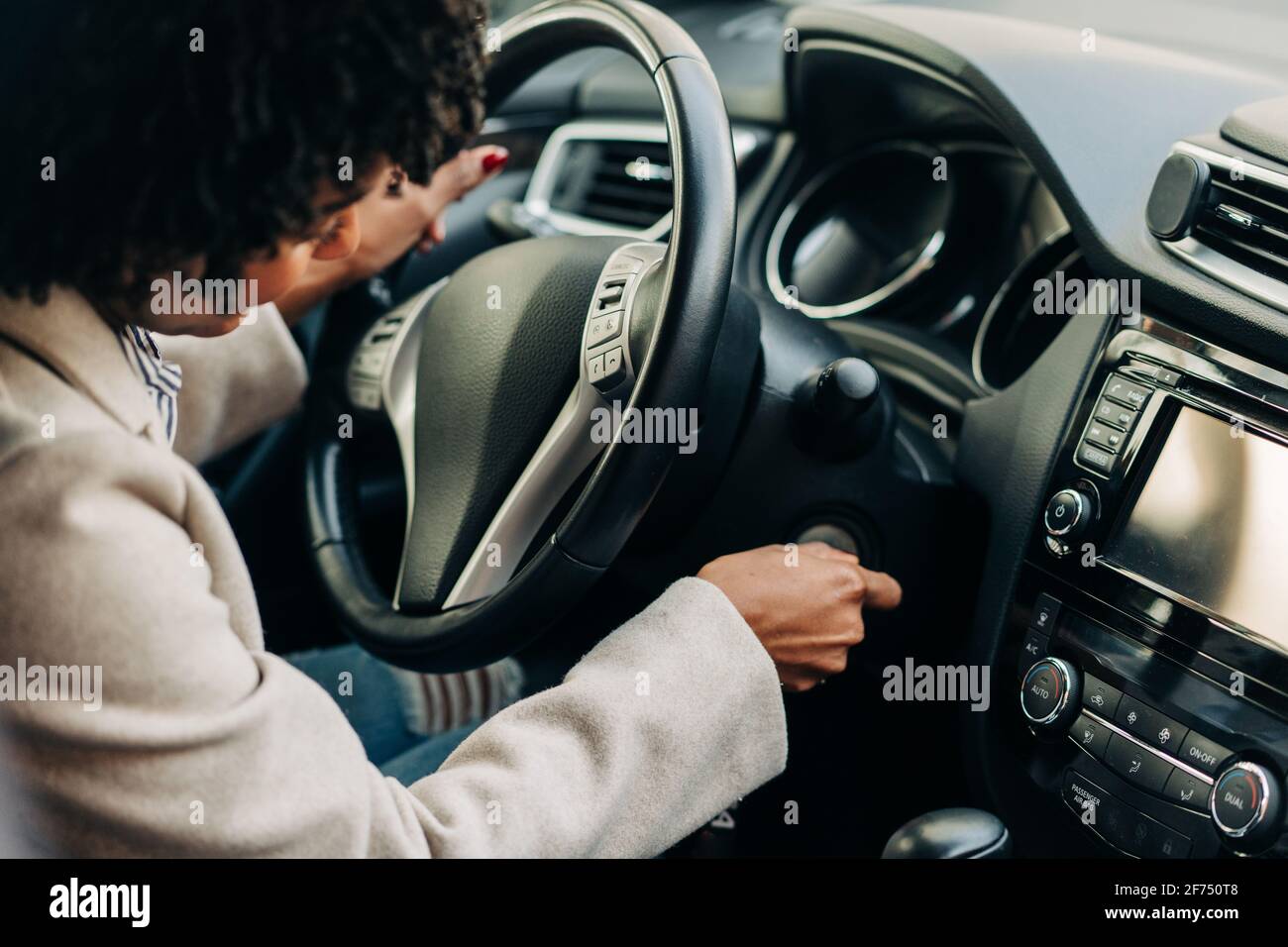 High angle of crop African American female driver starting auto engine ...